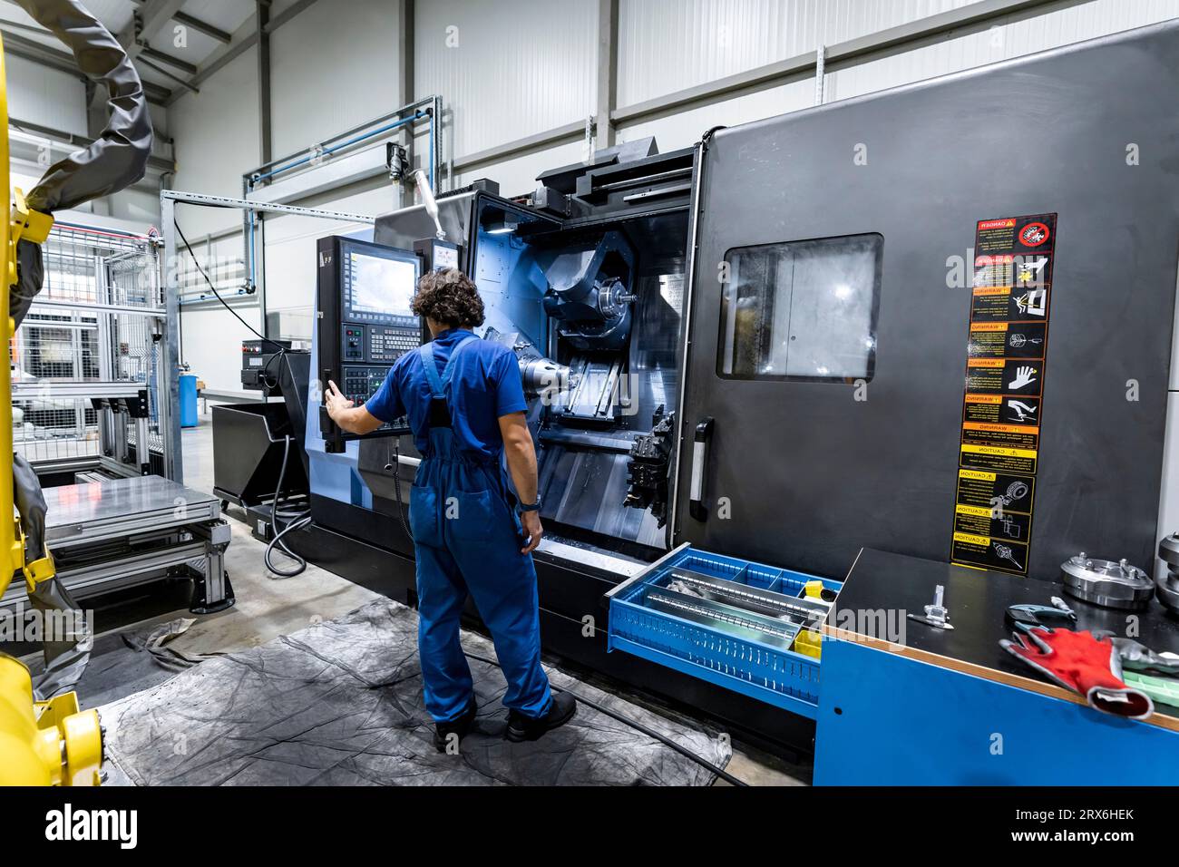 Technician operating cnc machinery in metal industry Stock Photo - Alamy