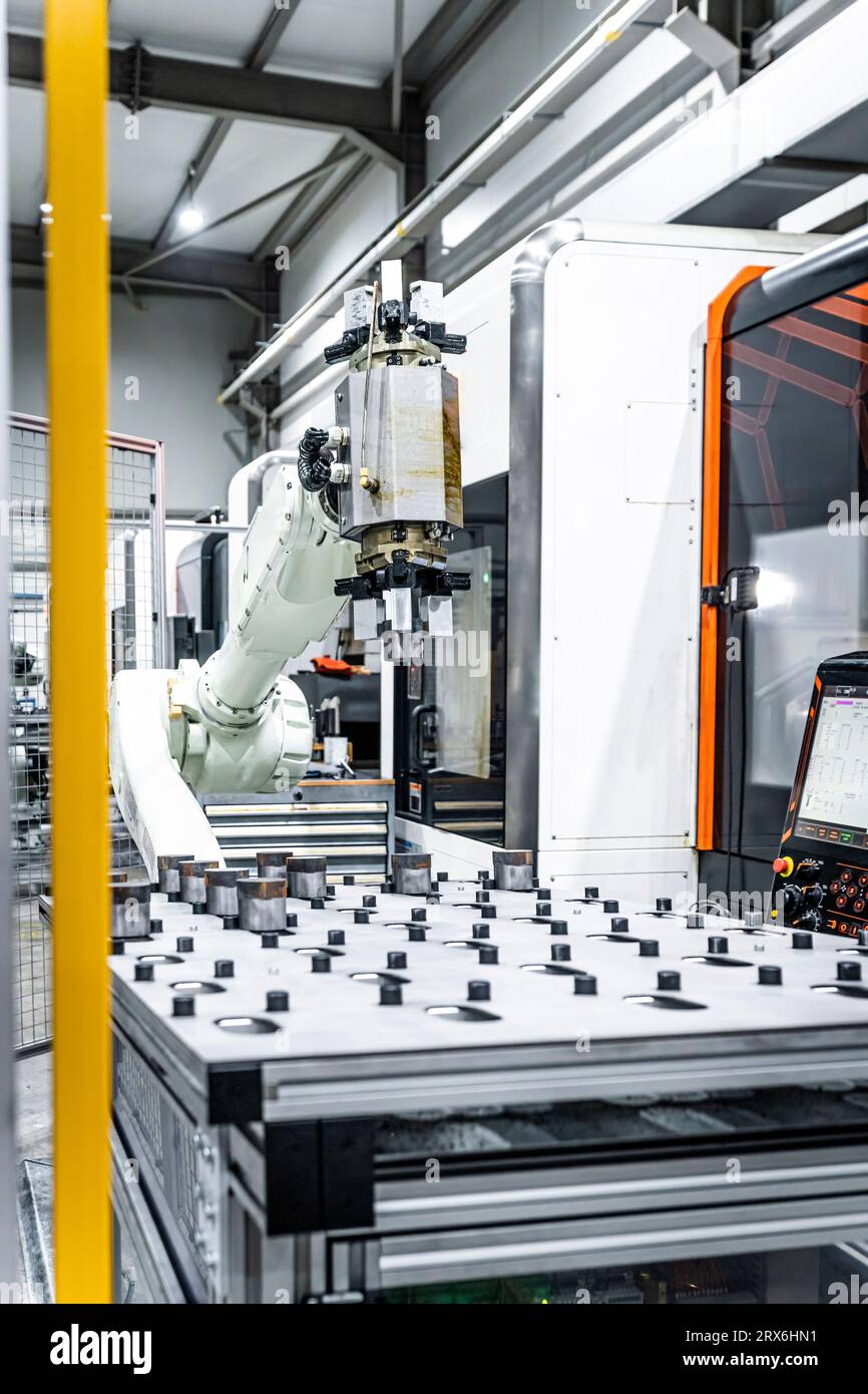 Robotic arm with cnc automated machinery in metal industry Stock Photo ...