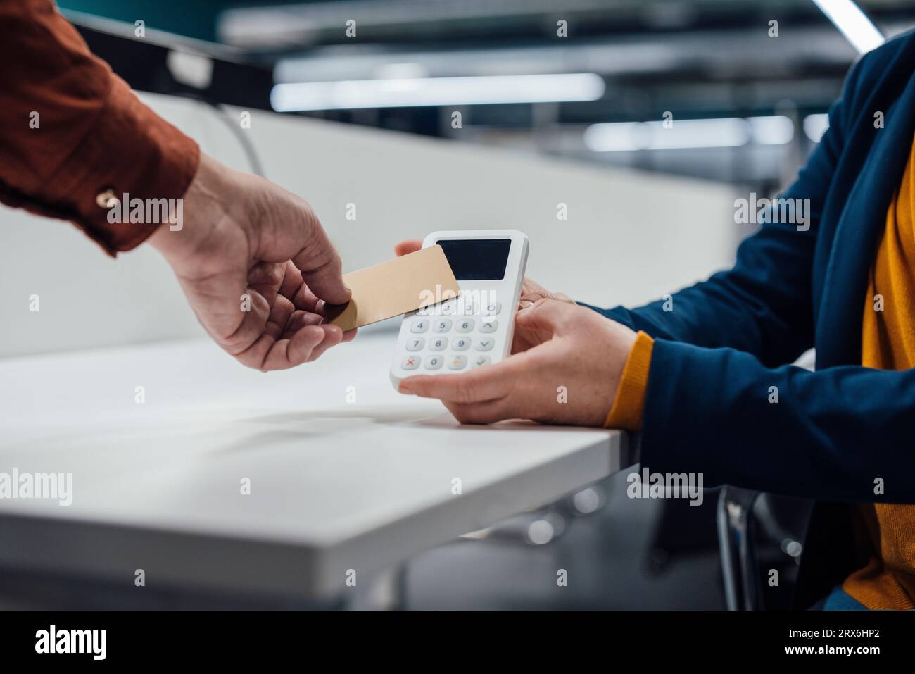 Hand of businessman paying on POS system at office Stock Photo - Alamy