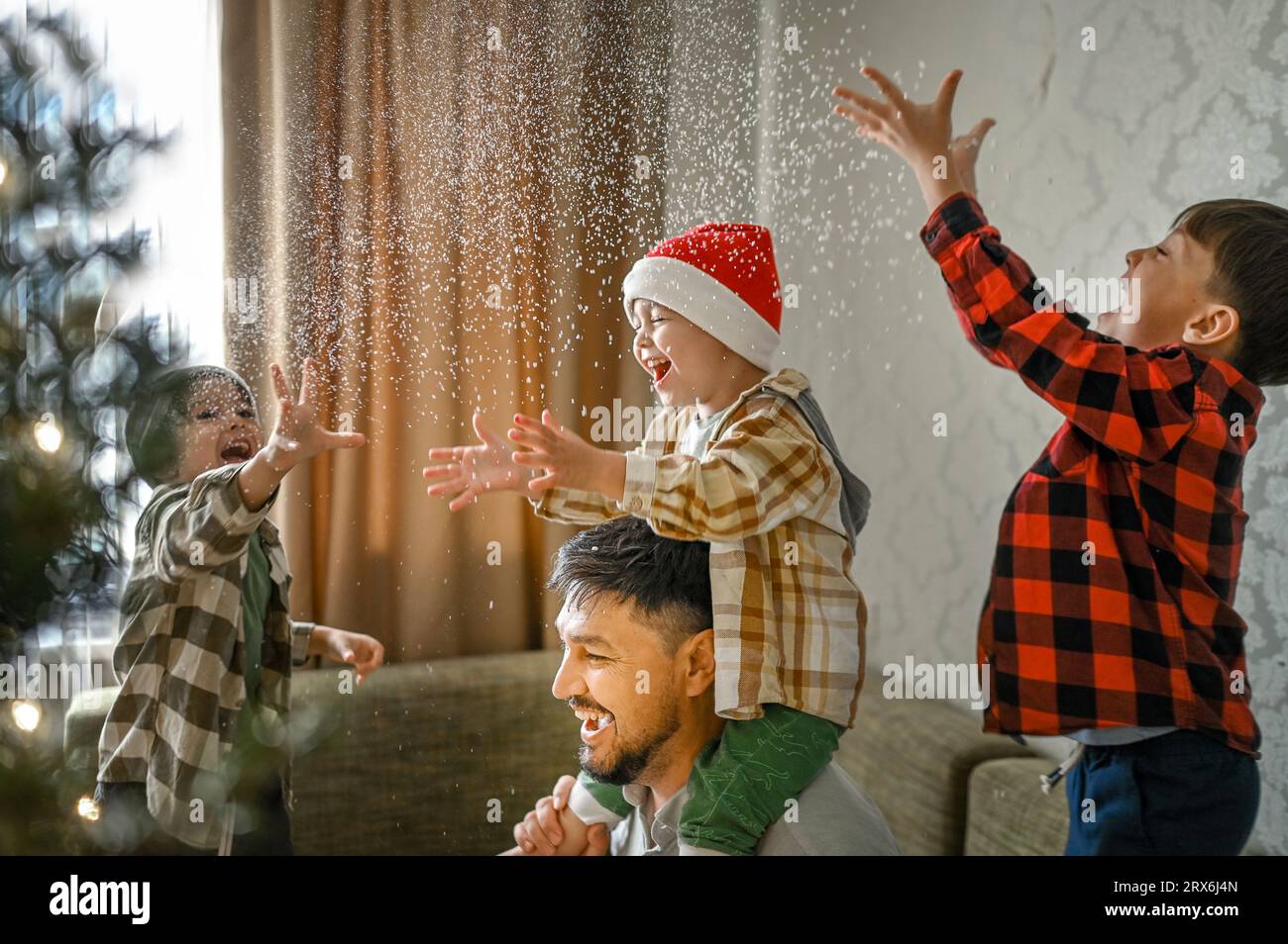 Father and sons playing with fake snow at home Stock Photo - Alamy
