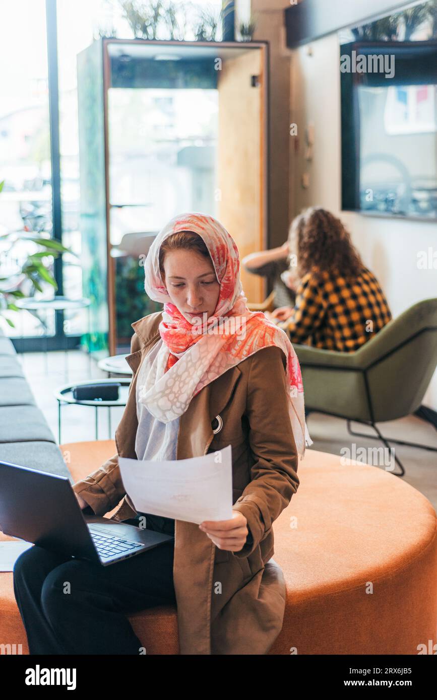 Gorgeous muslim woman in hijab working at office separately from her ...