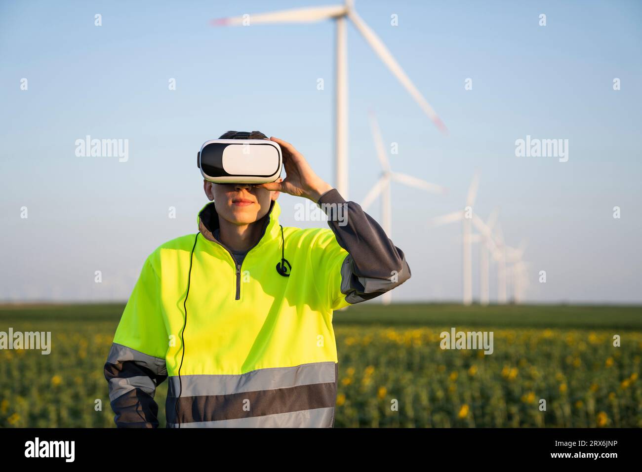 Engineer wearing virtual reality simulator standing in front of wind ...