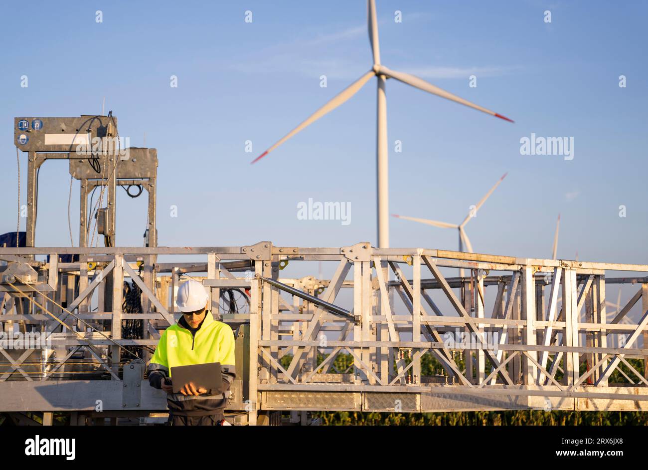 Engineer using laptop in front of wind turbine maintenance machine ...