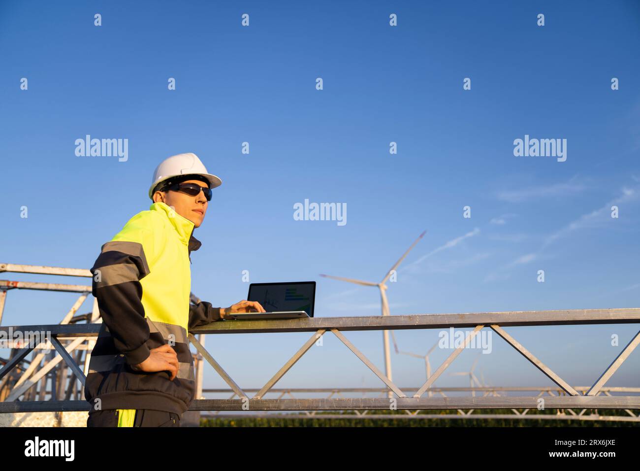Engineer with laptop on wind turbine maintenance machine Stock Photo ...