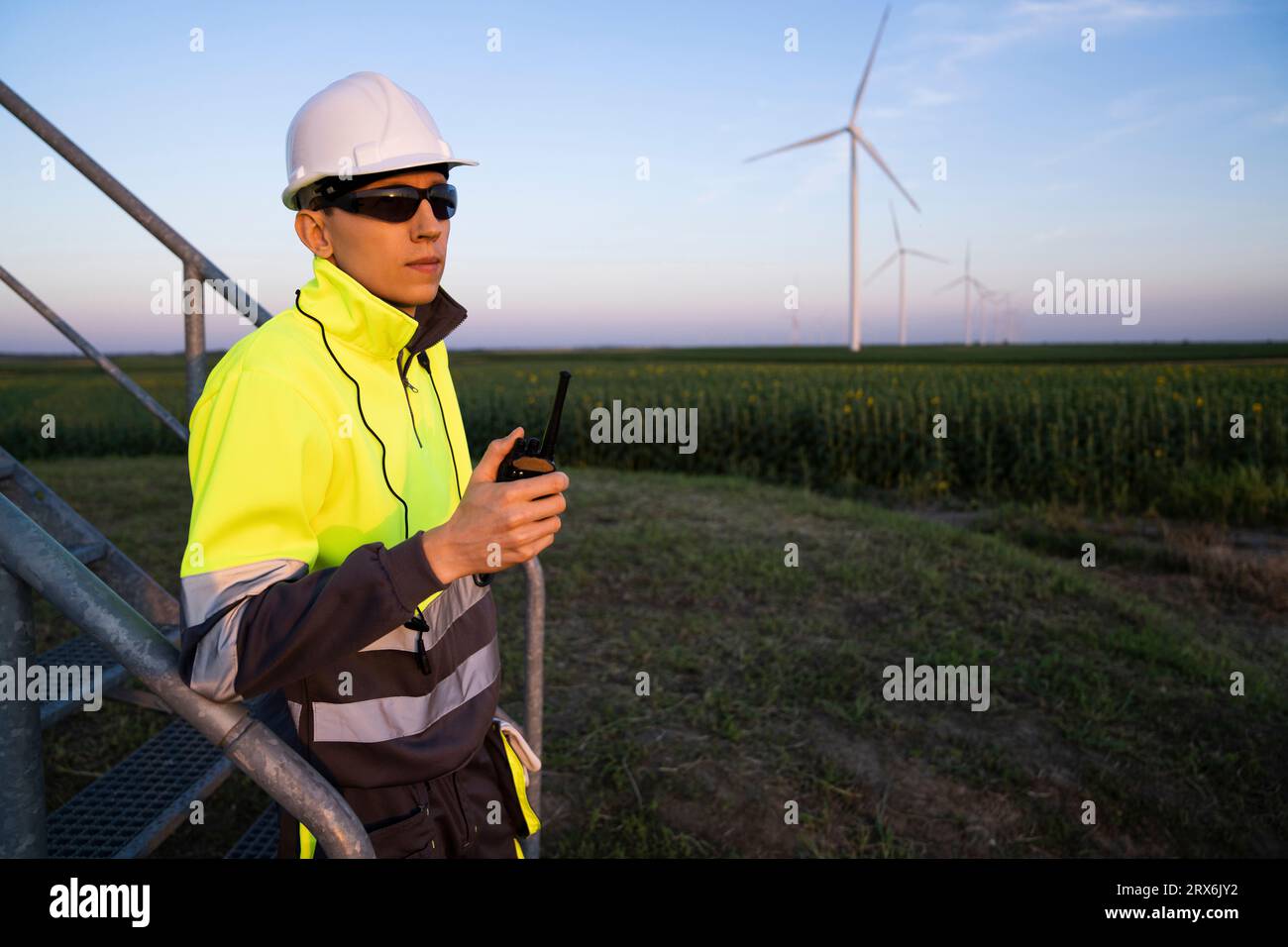 Engineer wearing reflective clothing by wind turbine field Stock Photo ...