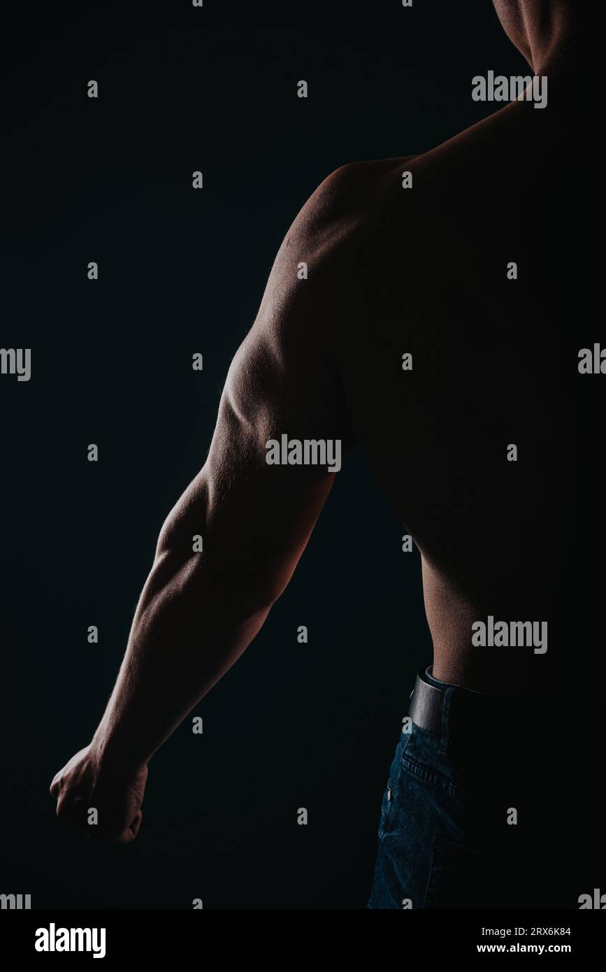 Strong, fit, male sports person showing his triceps on his left arm ...