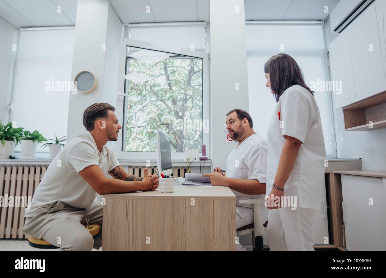 A group of doctors discussing medical outcomes, diagnosis, and ...