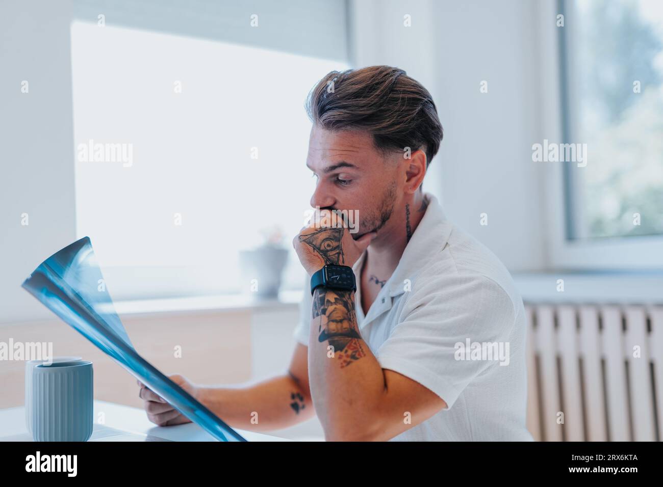 In a medical office, a worried patient reviewing negative x-ray results ...