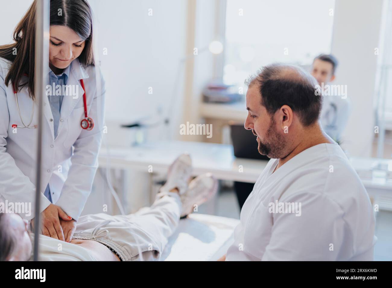 Doctors providing medical care; patient receiving infusion therapy and ...