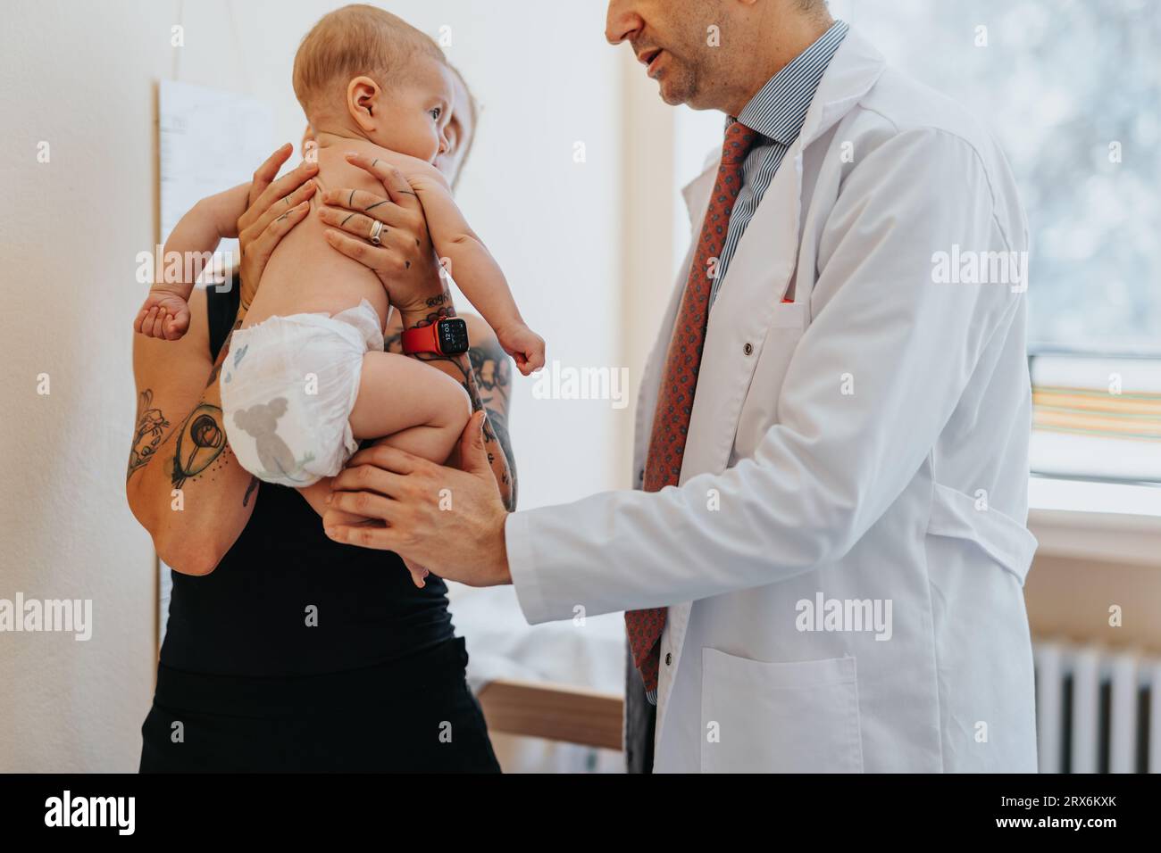 Doctor advising mother, giving appropriate treatment or therapy for her ...