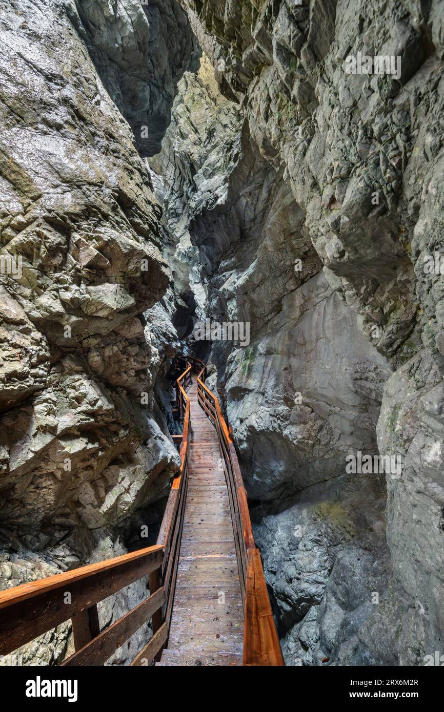 Wooden narrow bridge amidst rocky mountains Stock Photo - Alamy