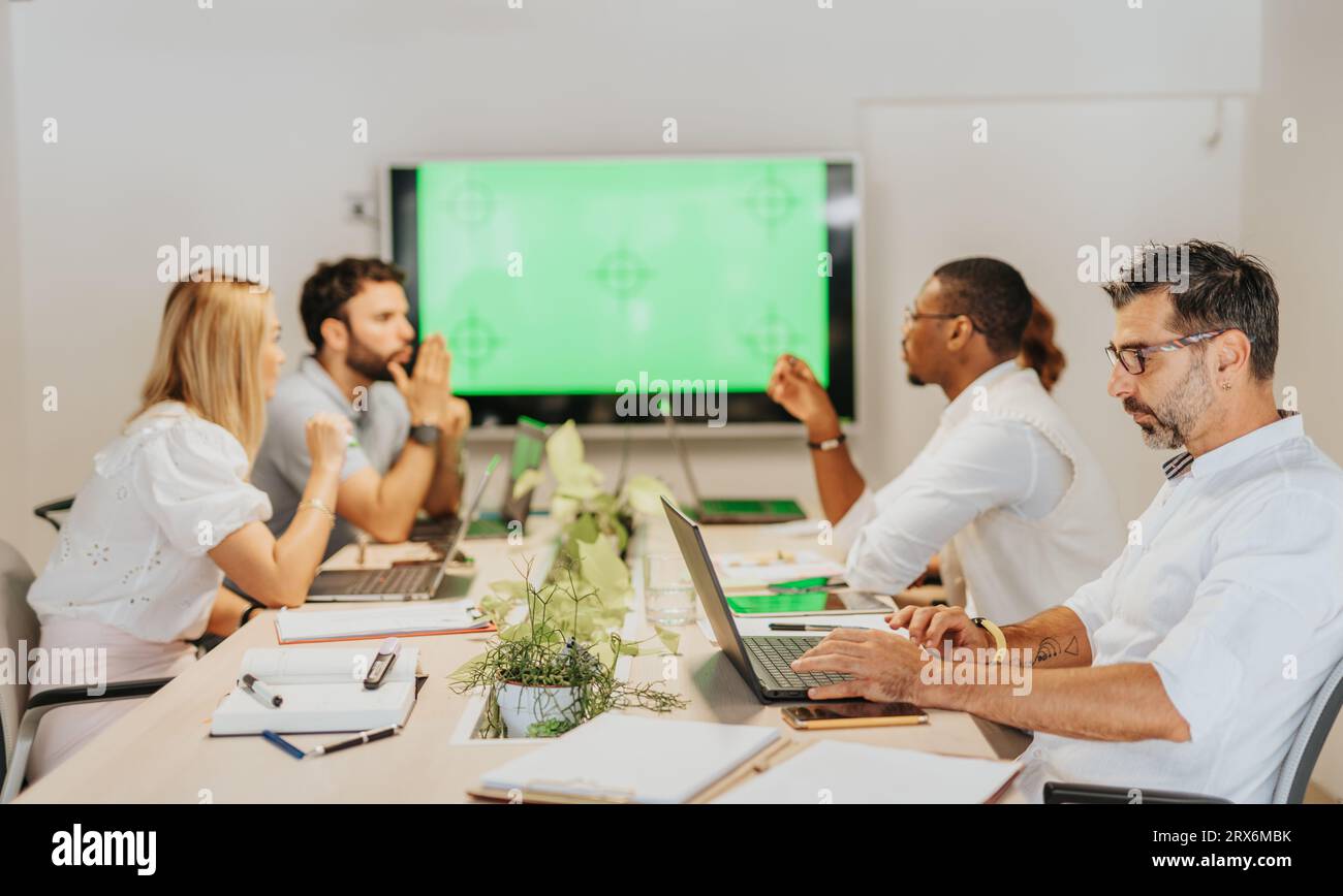 Business professionals in a modern office engage in a collaborative ...