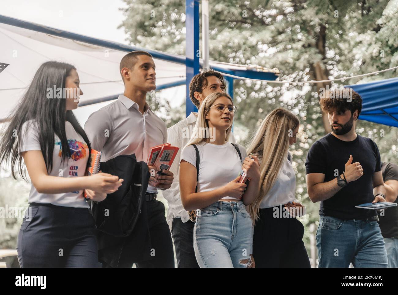 A diverse group of university students gathered in the campus yard ...