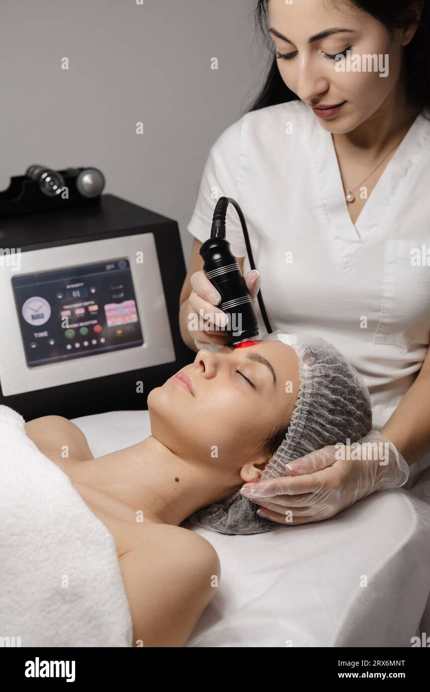 Young dermatologist doing Rf lifting procedure on woman's face in clinic Stock Photo - Alamy