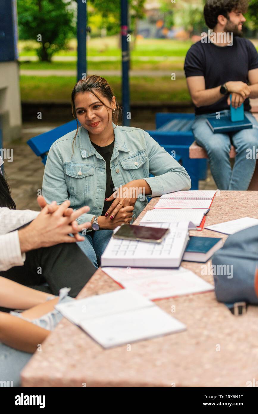 Group of young and beautiful classmates smiling and talking outside ...