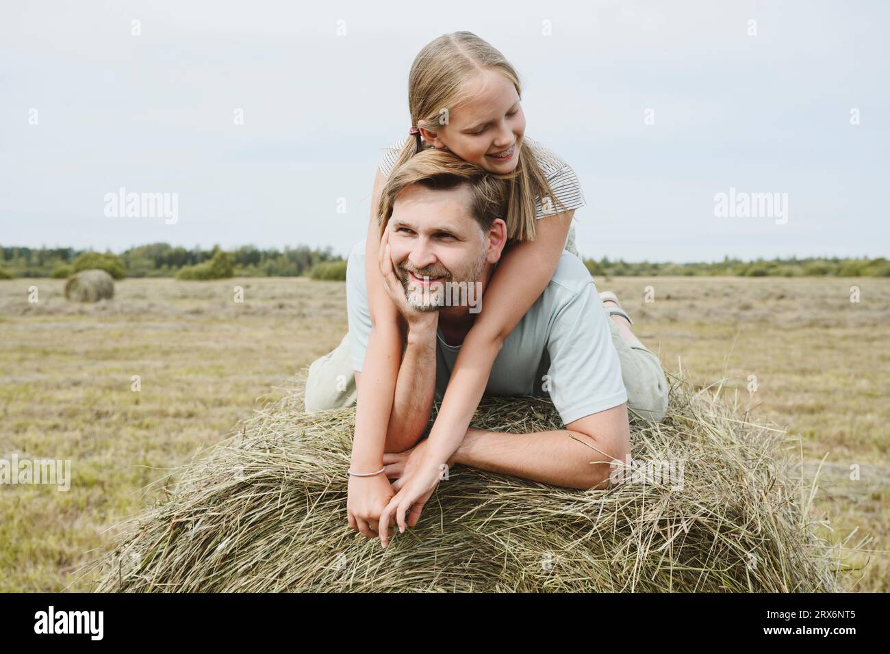 Happy daughter and father lying on hay in field Stock Photo - Alamy