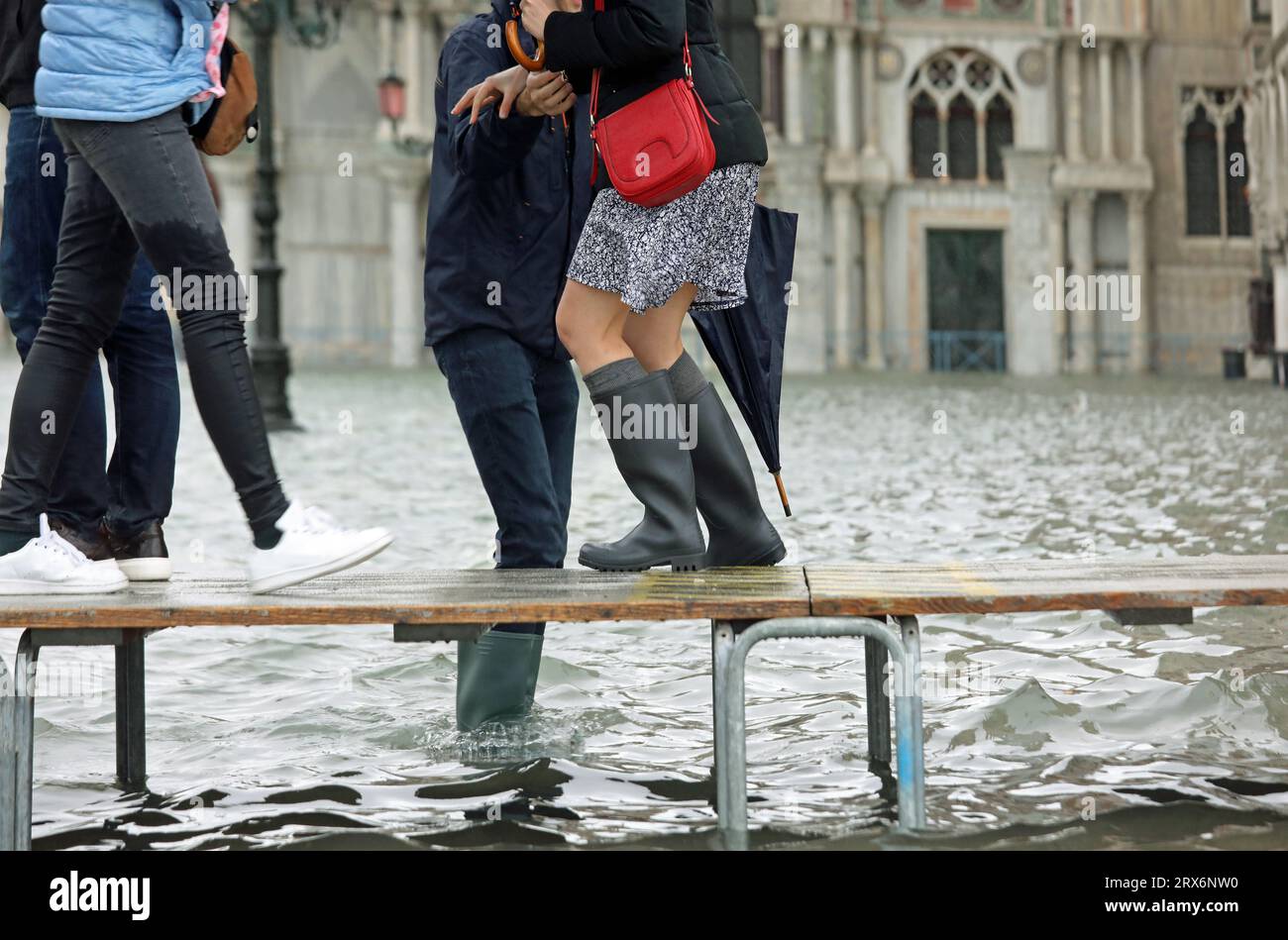 During high tide in Venice Italy people walk over the walkways to avoid ...