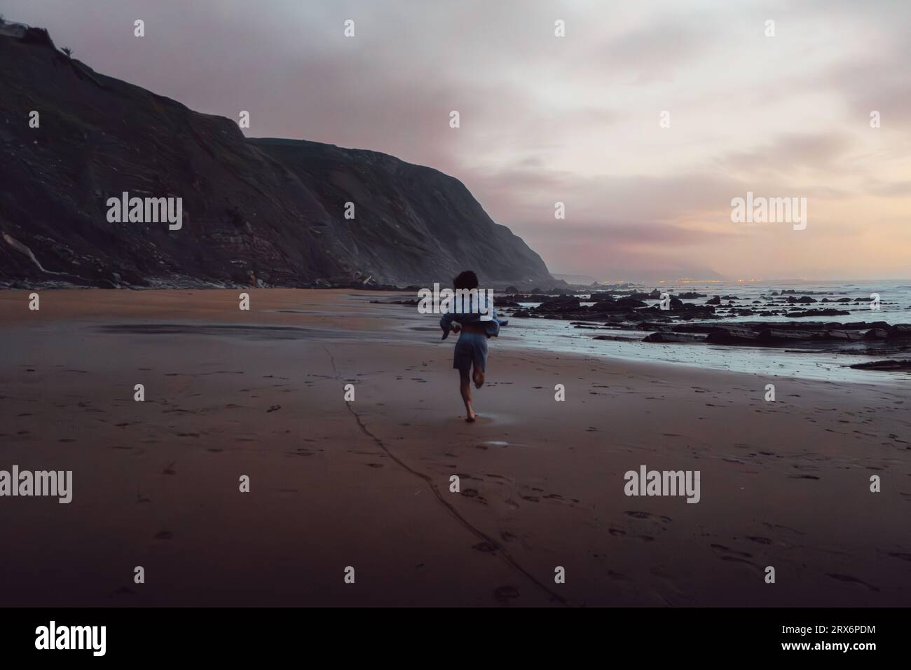 Young man running on sand at beach Stock Photo - Alamy