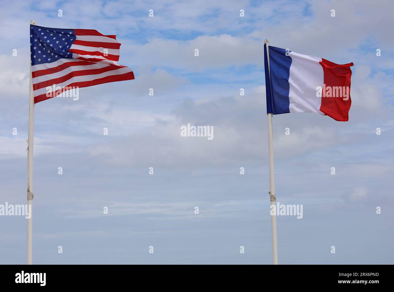 two American and French flags waving both have white blue and red ...