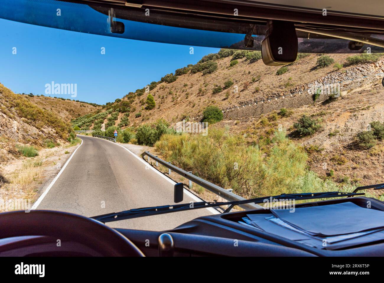 View from inside a truck of a narrow mountain road with curves and a ...