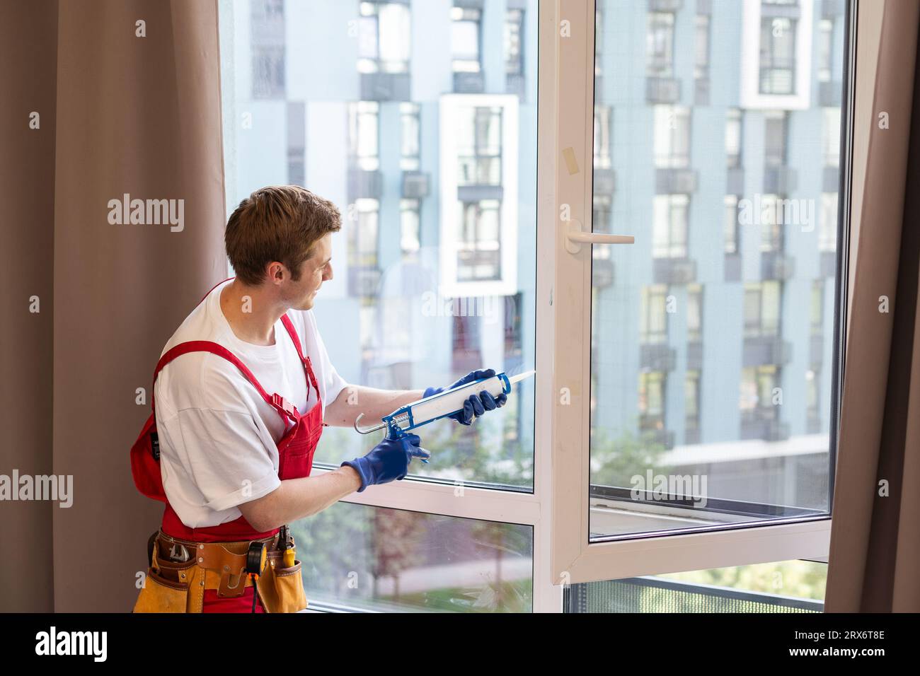 Construction worker installing window in house Stock Photo - Alamy