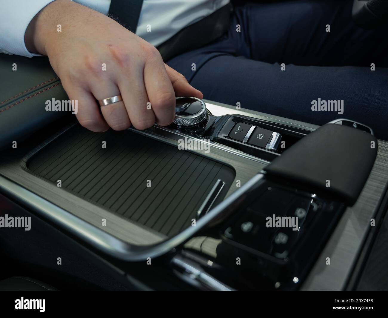 Close-up of a man's hands on the automatic transmission of a modern car ...