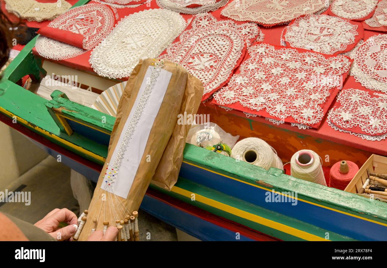 Gozo, Malta - 5 August 2023: Person making souvenir gifts in lace using ...