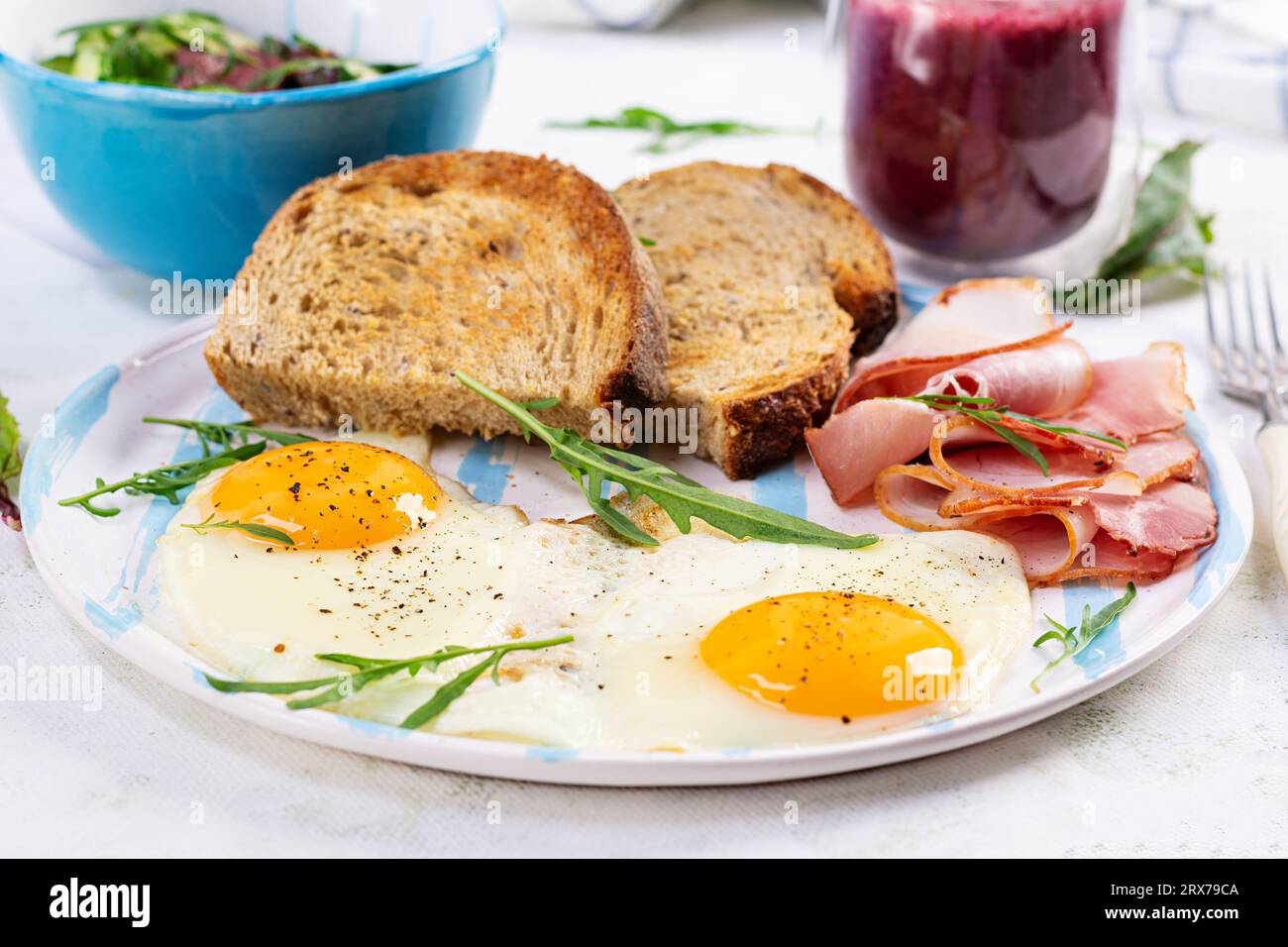 Breakfast. Fried egg, slices of ham and toasted bread Stock Photo - Alamy
