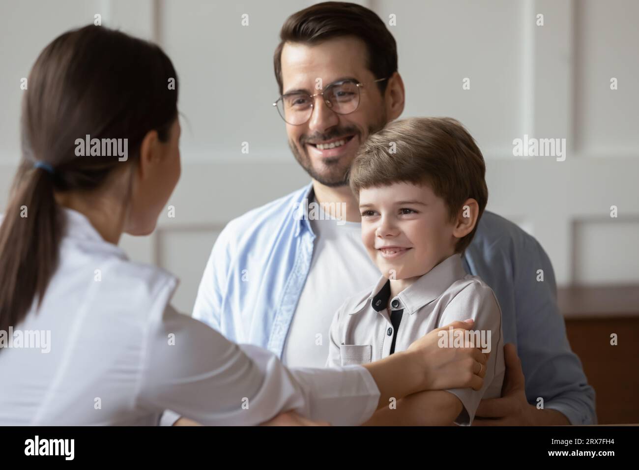 Close up female pediatrician supporting little boy, touching shoulder ...