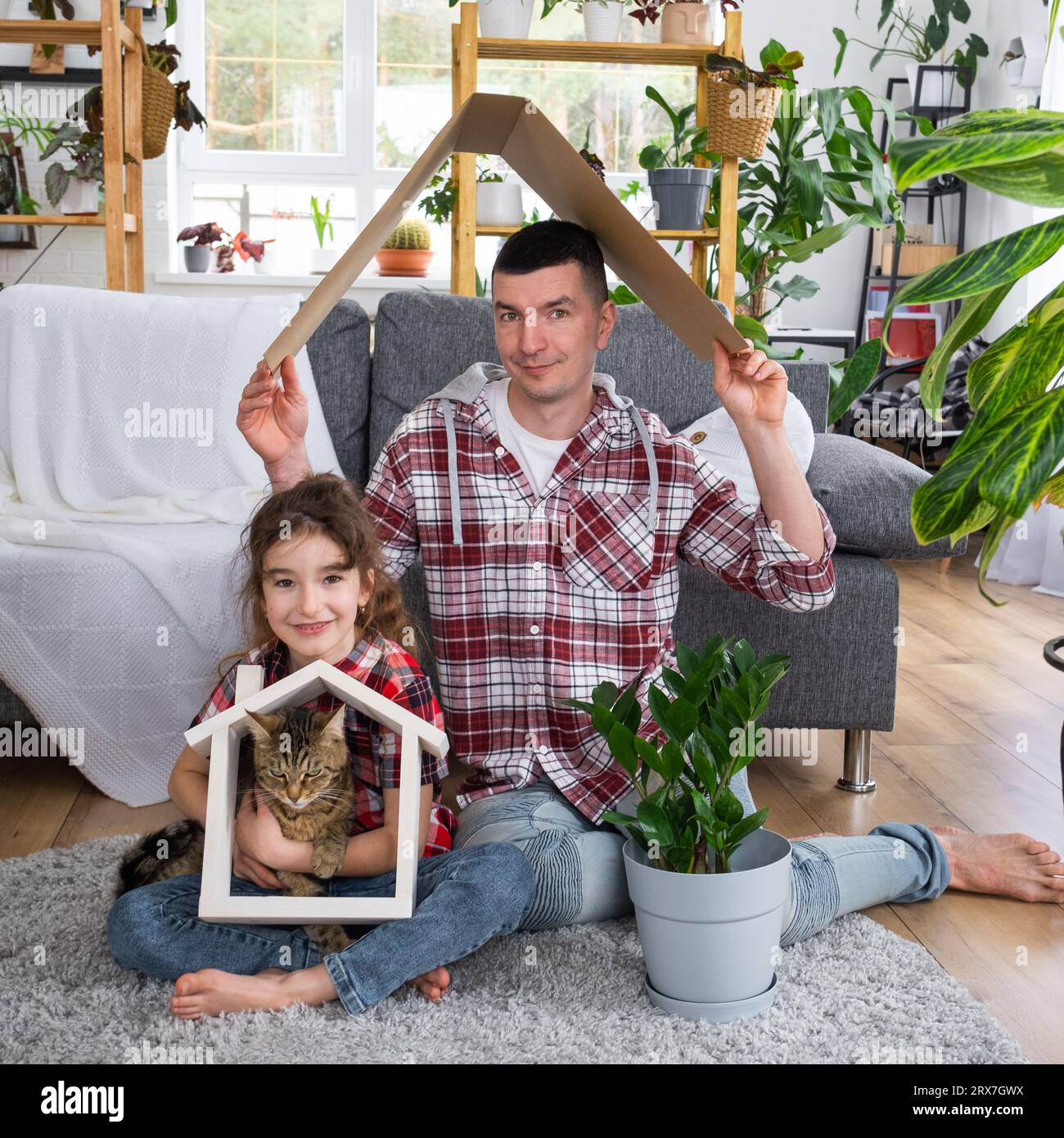 Incomplete family dad and daughter and pet cat are enjoying new home ...