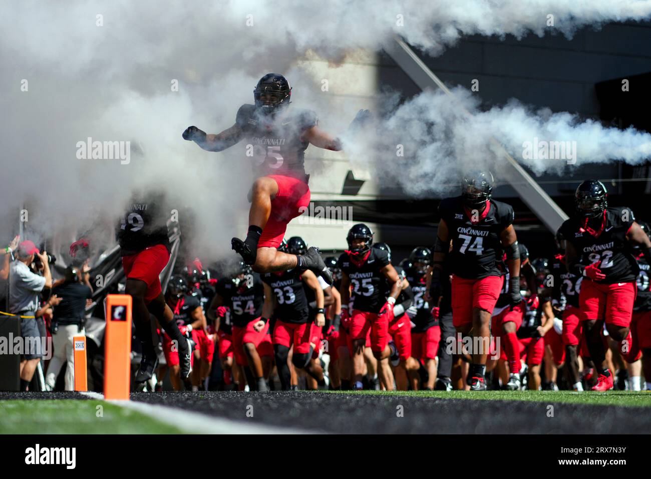 Cincinnati defensive end Justin Wodtly leaps as he takes the field with ...