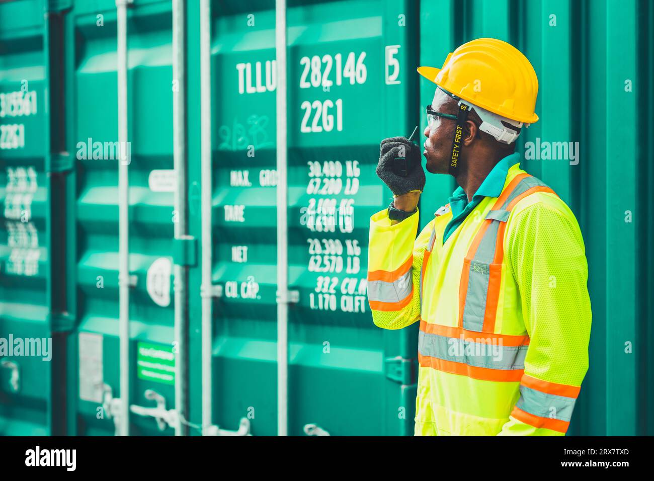 Worker control loading containers cargo at port shipyard with green ...