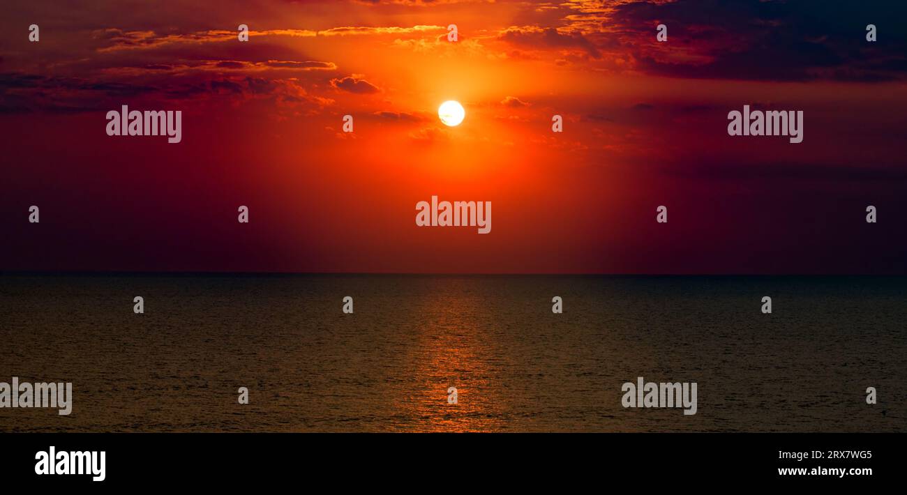 Bright red sunrise over a tropical beach. Wide photo Stock Photo - Alamy