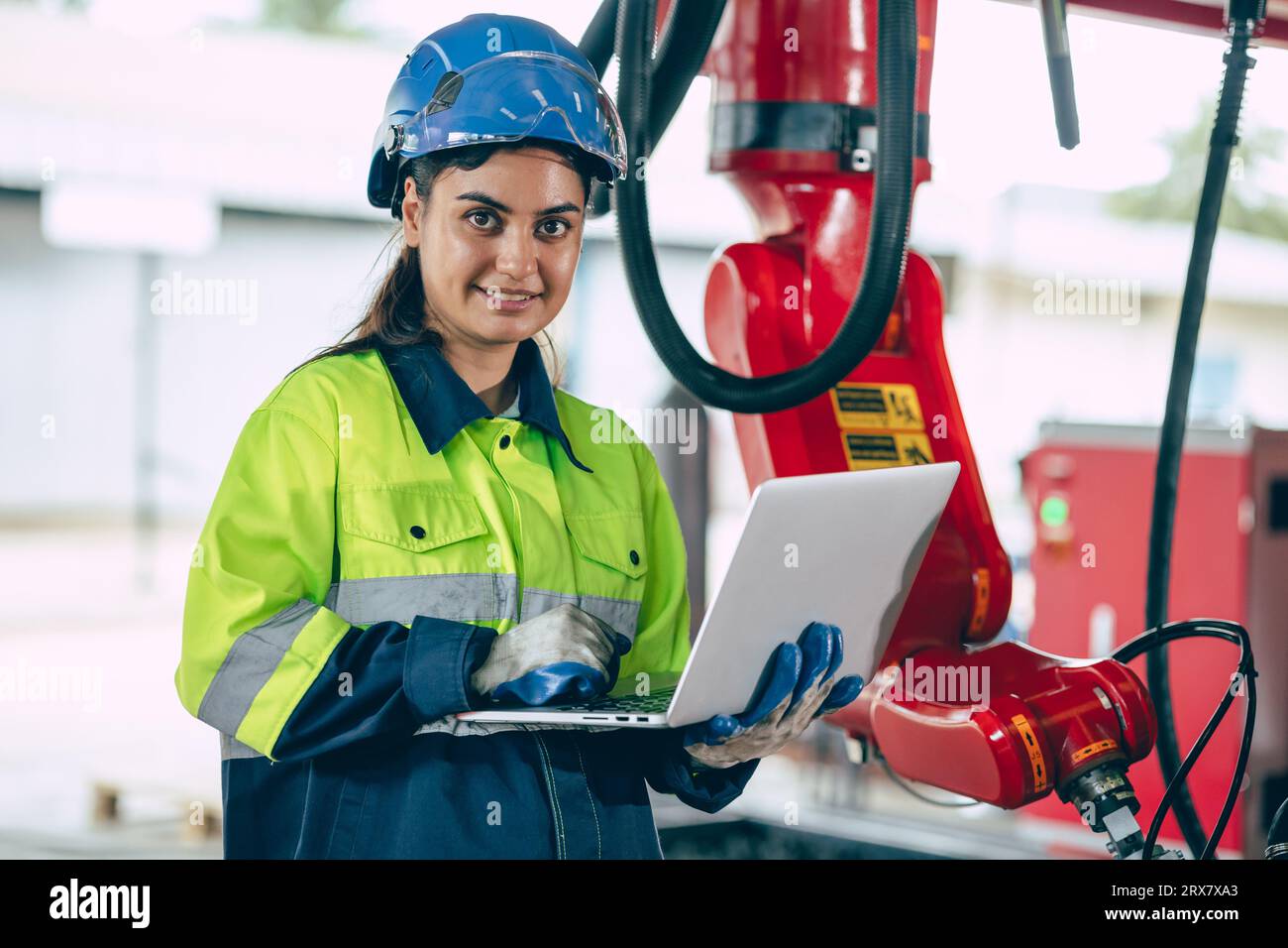 Portrait Indian young smart engineer woman worker confident look with safety suit work in ...