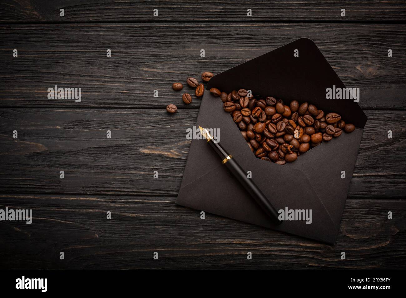 Coffee beans on a kraft paper envelope. Black background. High quality ...