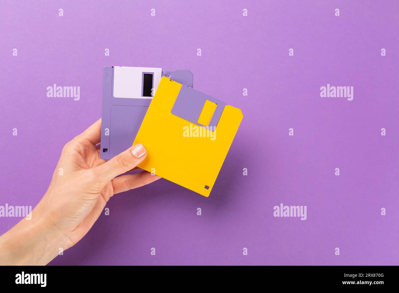 Hand holding floppy disk on color background, technology concept Stock ...