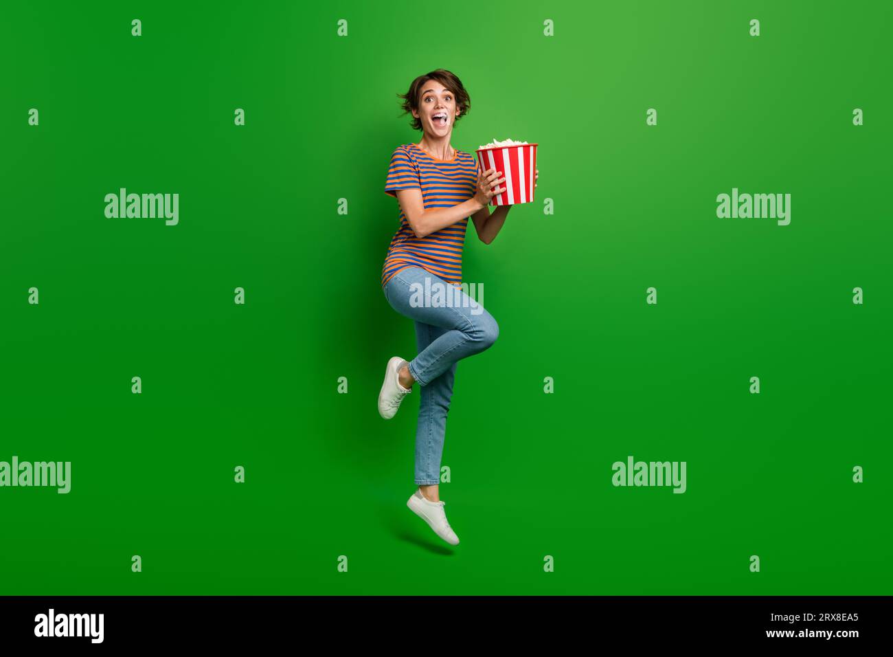 Full body photo of astonished overjoyed lady jump hold popcorn bucket ...