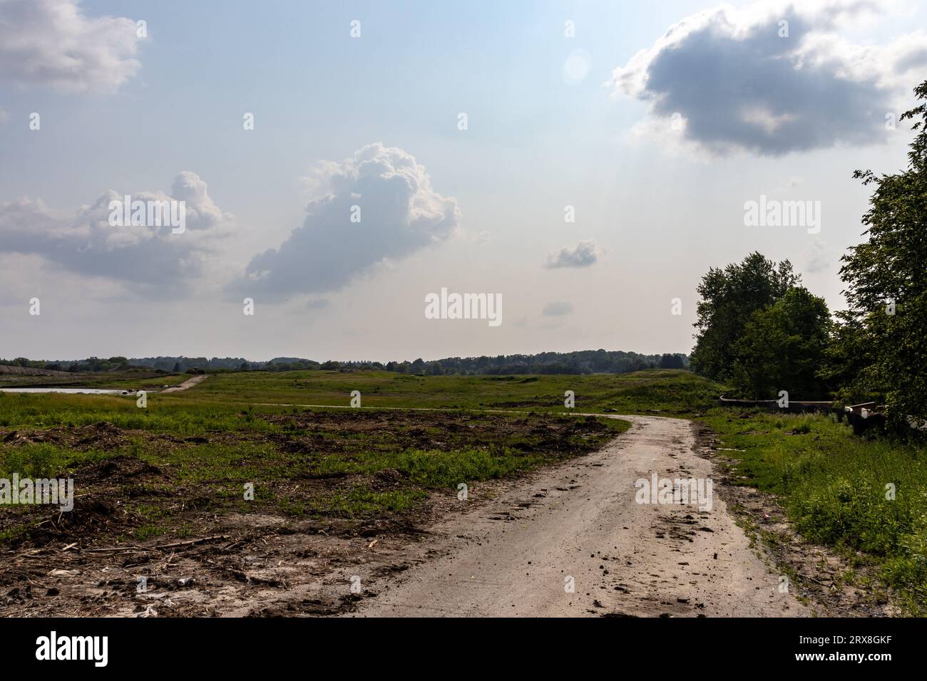 Dirt road - rural area - winding and bumpy - grass and shrubbery - blue ...