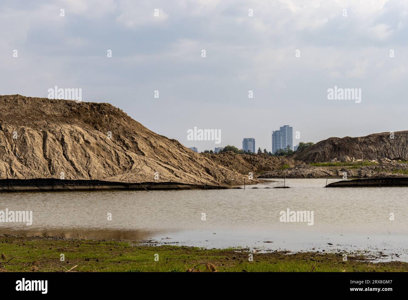 Barren landscape with water and city skyline - dry, cracked earth and ...