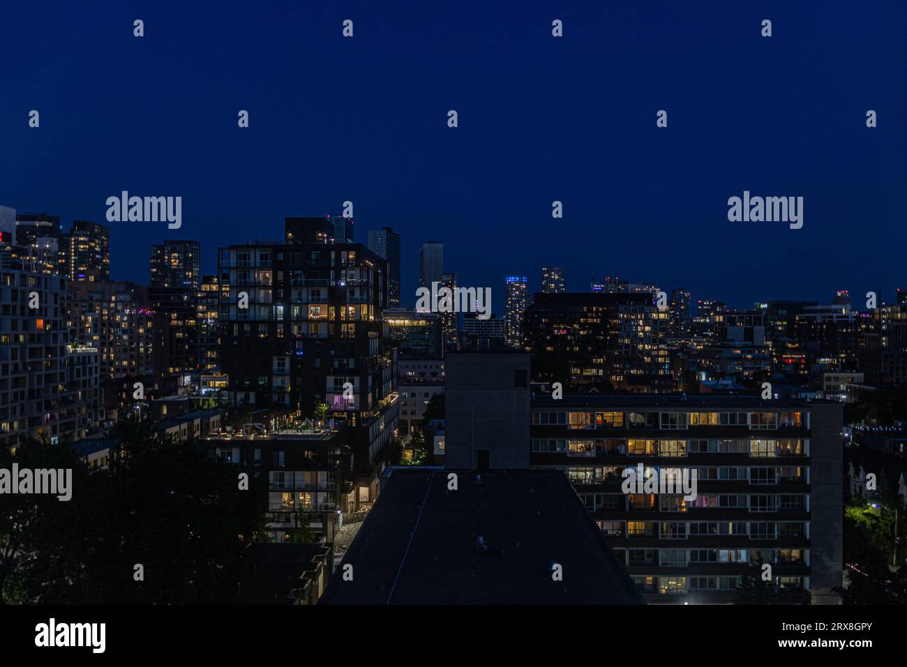 A city skyline at night - colorful lights from buildings contrast with ...