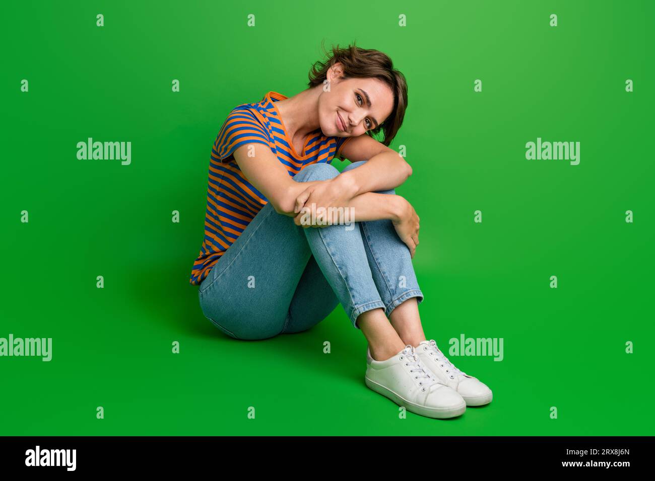 Full size photo of gorgeous satisfied girl sit floor hands hug legs ...