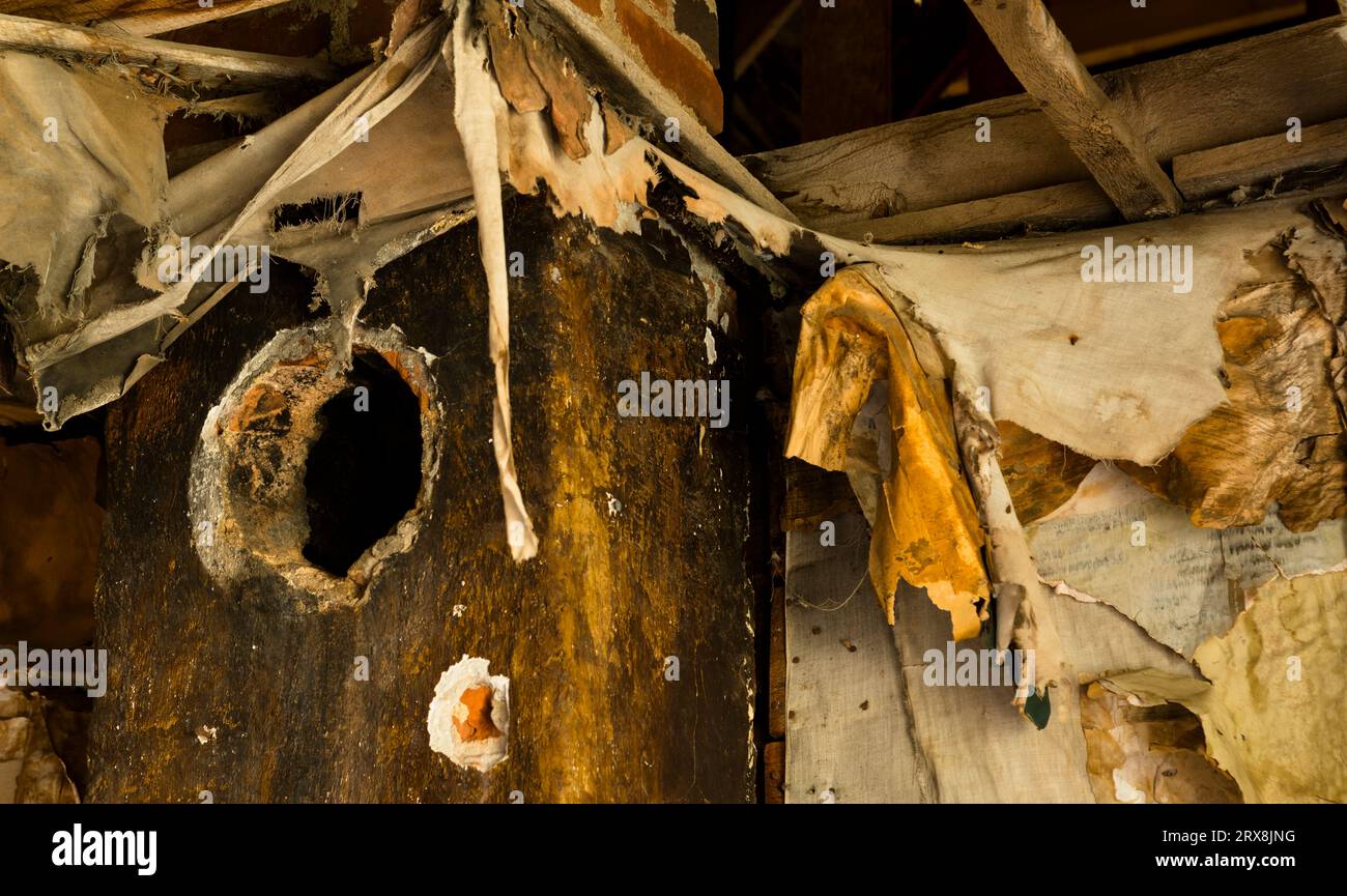 Chimney with an open flue inside an old miner’s house with aged-layers ...