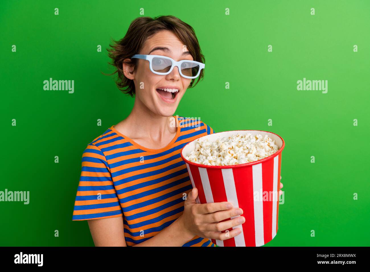 Photo portrait of attractive young woman hold popcorn bucket eating ...
