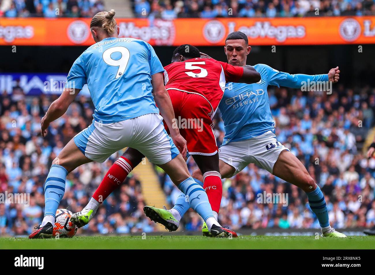 Erling Haaland and Phil Foden of Manchester City challenge Taiwo ...