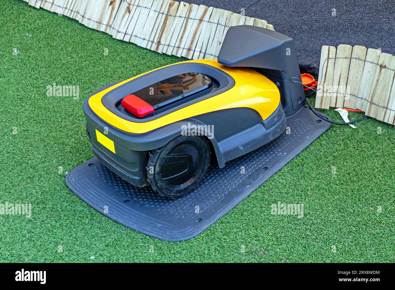 Lawn mower autonomous robot in grass field outdoors on a charging ...