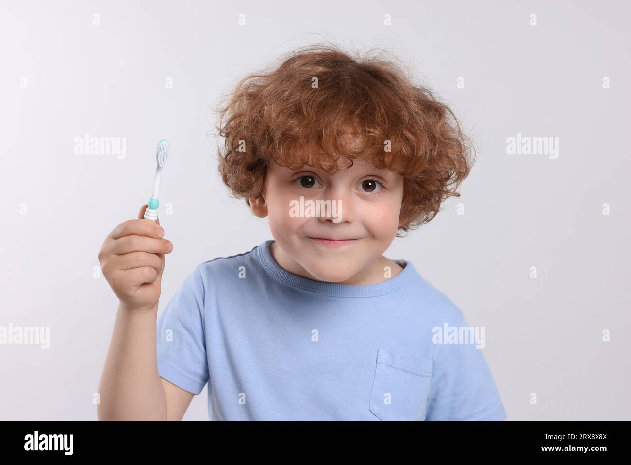 Cute little boy holding plastic toothbrush on white background Stock ...