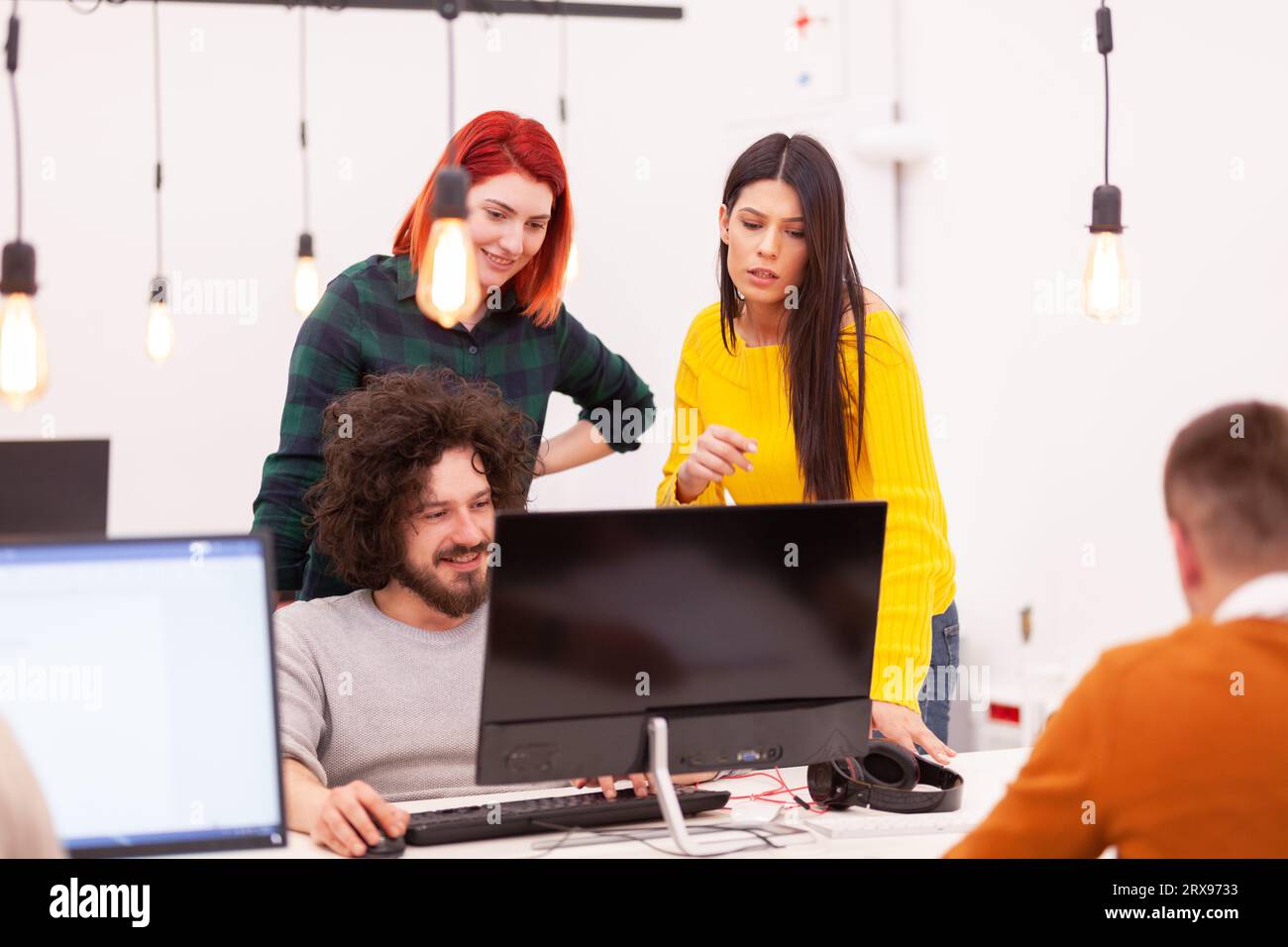 Group of multiethnic colleagues working on desktop computers in a ...