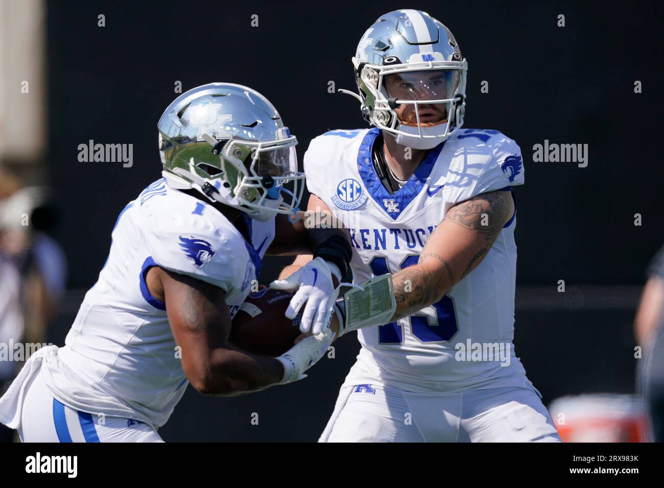 Kentucky quarterback Devin Leary, right, hands the ball to running back ...