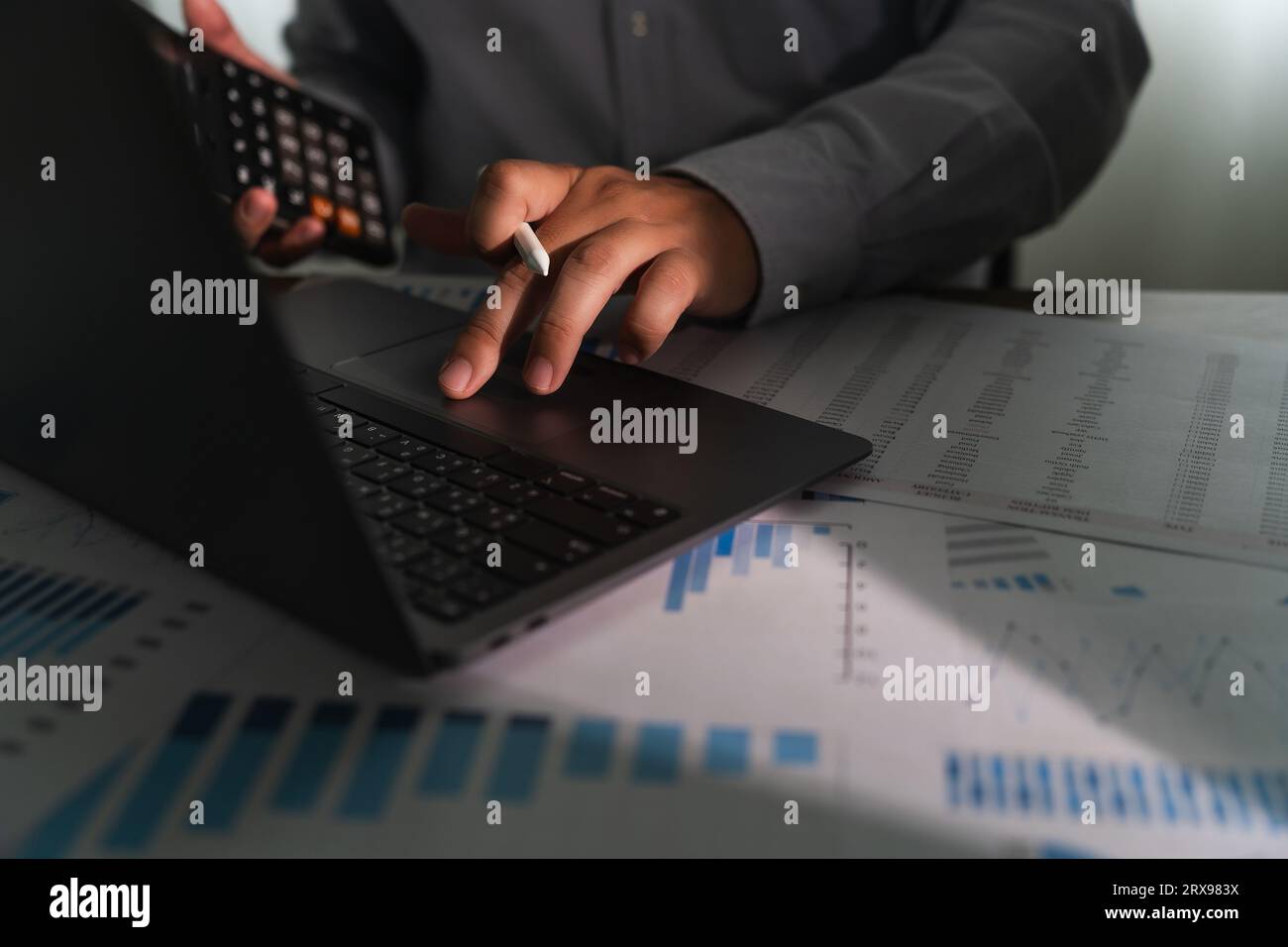 close-up of a businessman using a computer laptop to analyze finances ...