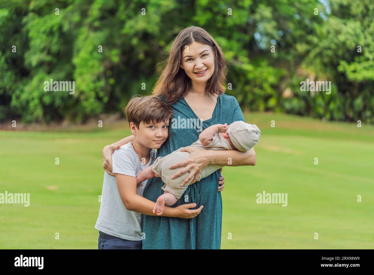 A happy 40-year-old mother cradles her newborn with her adult son in a ...